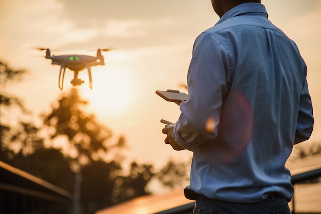 Man Operating A Drone With Remote Control Drone Pilotage At Sunset