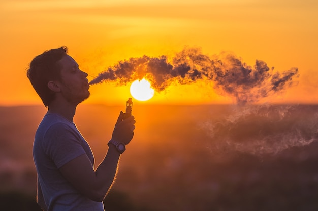 Premium Photo The Man Smoke An Electric Cigarette On The Background