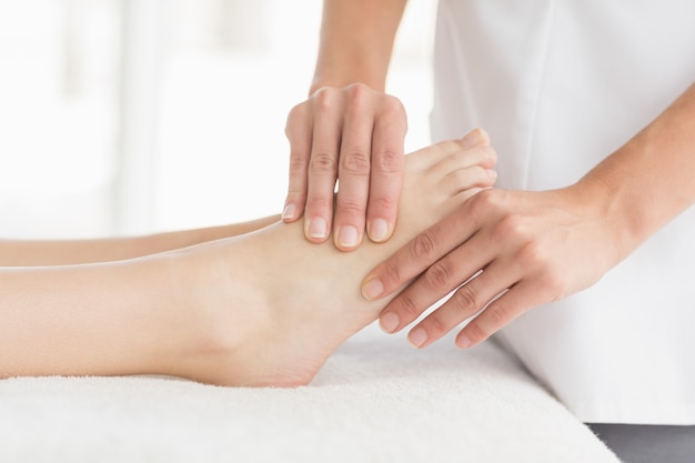 Premium Photo Midsection Of Masseur Giving Foot Massage To Woman