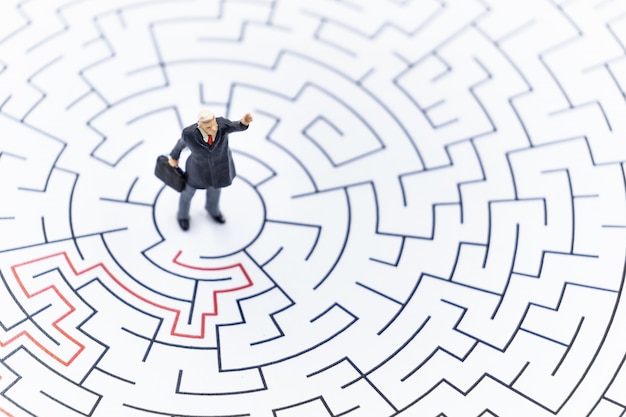 Premium Photo | Miniature people businessman standing on center of maze ... Premium Photo | Miniature people businessman standing on center of maze ...