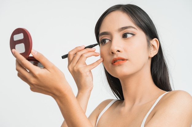 Premium Photo Mixed Race Asian Woman Putting Eye Liner On Eyelid On
