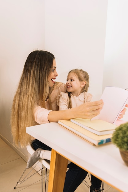 Free Photo Mother And Daughter With Book Looking At Each Other