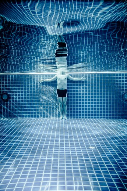 Premium Photo | Persons standing under water in a swimming pool Premium Photo | Persons standing under water in a swimming pool