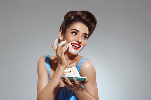 Free Photo | Portrait of beautiful pin-up woman eating cake Free Photo | Portrait of beautiful pin-up woman eating cake