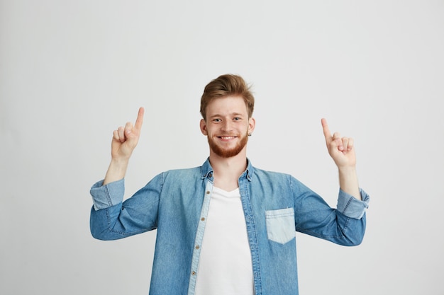 Free Photo | Portrait of cheerful young man smiling pointing finger up. Free Photo | Portrait of cheerful young man smiling pointing finger up.