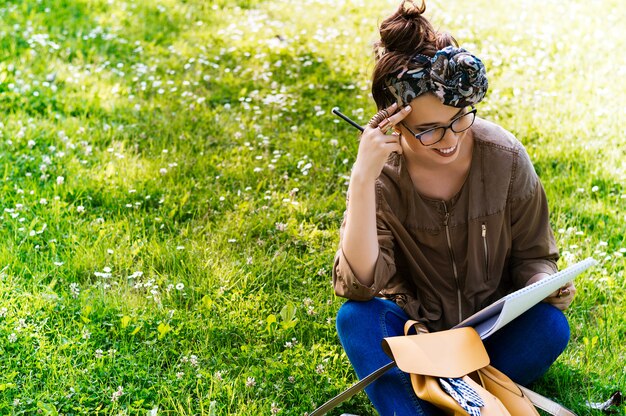 Premium Photo Pretty Young Woman Sitting On The Grass And Reading