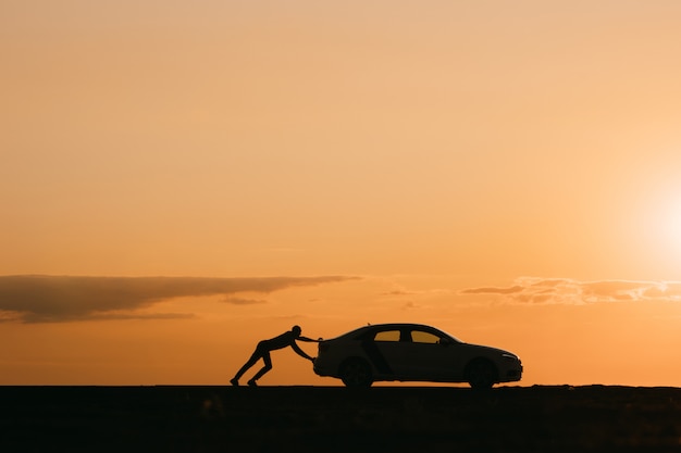 Premium Photo | Silhouette of man driver pushing his car along on empty ... Premium Photo | Silhouette of man driver pushing his car along on empty ...
