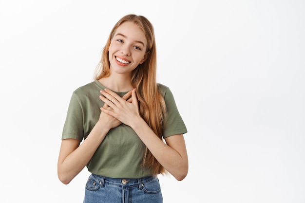 Free Photo Smiling Blond Woman Holding Hands On Heart And Looking