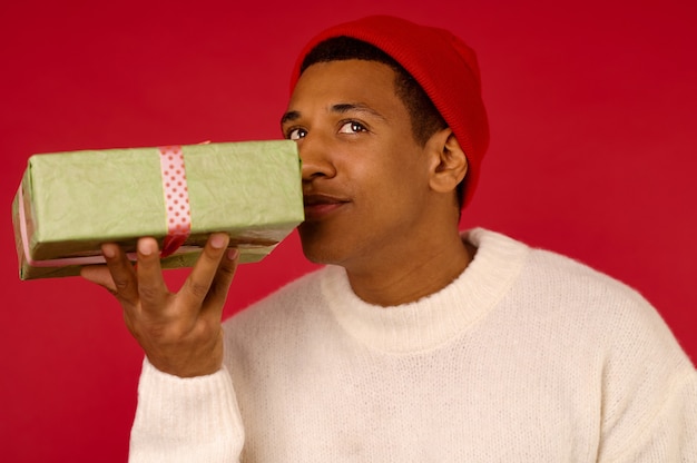 Premium Photo | Smiling dark-skinned young guy with gift boxes in hands Premium Photo | Smiling dark-skinned young guy with gift boxes in hands