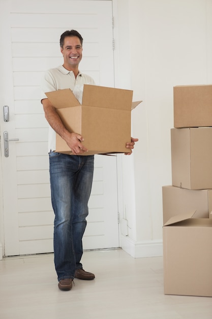 Premium Photo | Smiling man carrying boxes in new house Premium Photo | Smiling man carrying boxes in new house