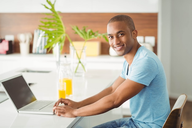 Premium Photo | Smiling man using laptop at home Premium Photo | Smiling man using laptop at home