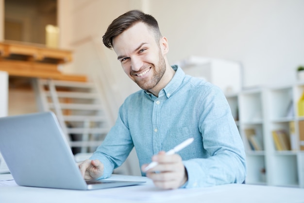 Premium Photo | Smiling man using laptop Premium Photo | Smiling man using laptop