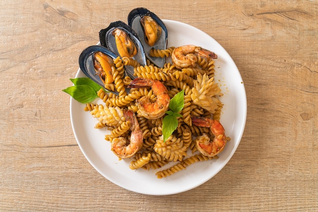Premium Photo Stir Fried Spiral Pasta With Seafood And Basil Sauce