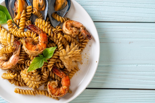 Premium Photo Stir Fried Spiral Pasta With Seafood And Basil Sauce