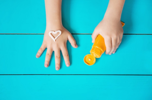 Premium Photo | Sunscreen on the hand of a child. selective focus. Premium Photo | Sunscreen on the hand of a child. selective focus.