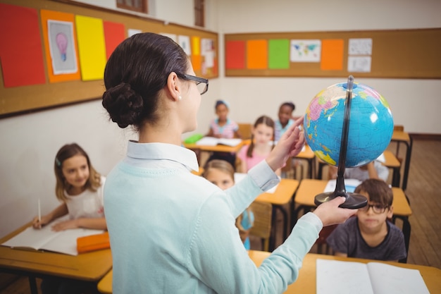 Premium Photo | Teacher showing pupils a globe Premium Photo | Teacher showing pupils a globe