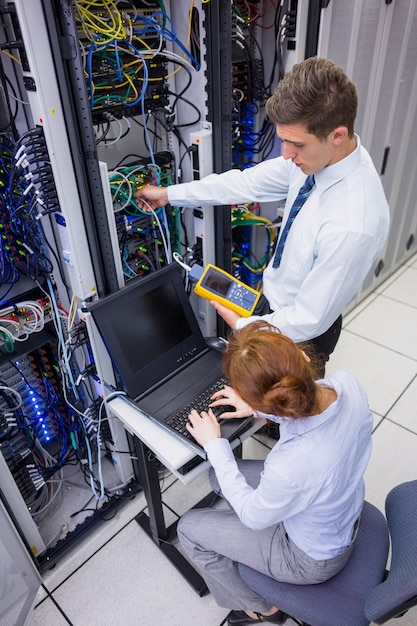 Premium Photo | Team of technicians using digital cable analyser on servers Premium Photo | Team of technicians using digital cable analyser on servers