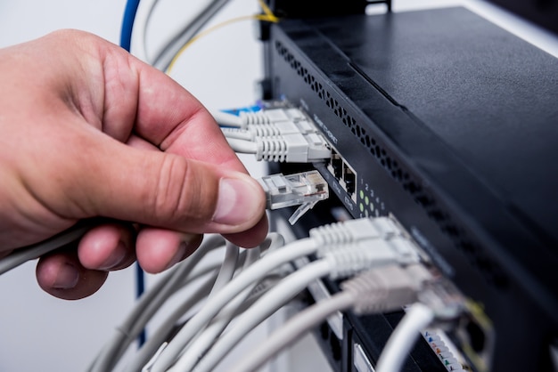 Premium Photo | Technician connecting network cables to switches ... Premium Photo | Technician connecting network cables to switches ...