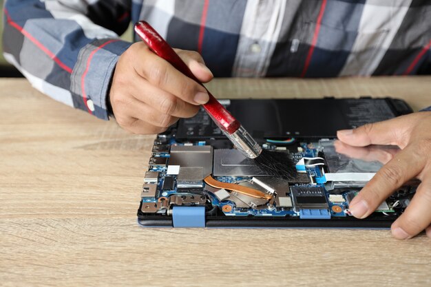 Premium Photo | Technician man using a dusting brush to clean laptop ... Premium Photo | Technician man using a dusting brush to clean laptop ...