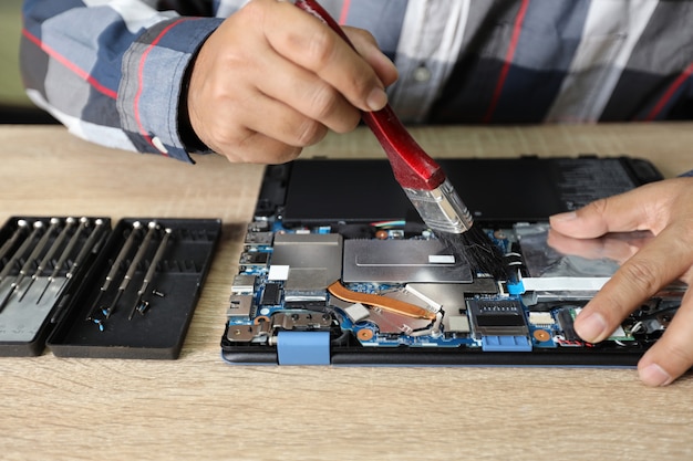 Premium Photo | Technician man using a dusting brush to clean laptop ... Premium Photo | Technician man using a dusting brush to clean laptop ...