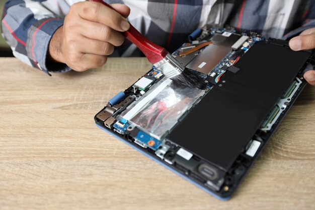 Premium Photo | Technician man using a dusting brush to clean laptop ... Premium Photo | Technician man using a dusting brush to clean laptop ...