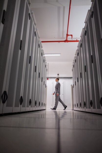 Premium Photo | Technician walking in server hallway in large data center Premium Photo | Technician walking in server hallway in large data center
