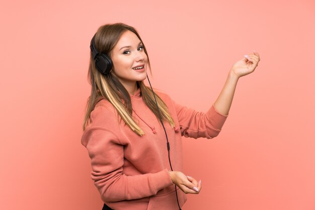 Premium Photo | Teenager girl listening music over isolated pink background Premium Photo | Teenager girl listening music over isolated pink background