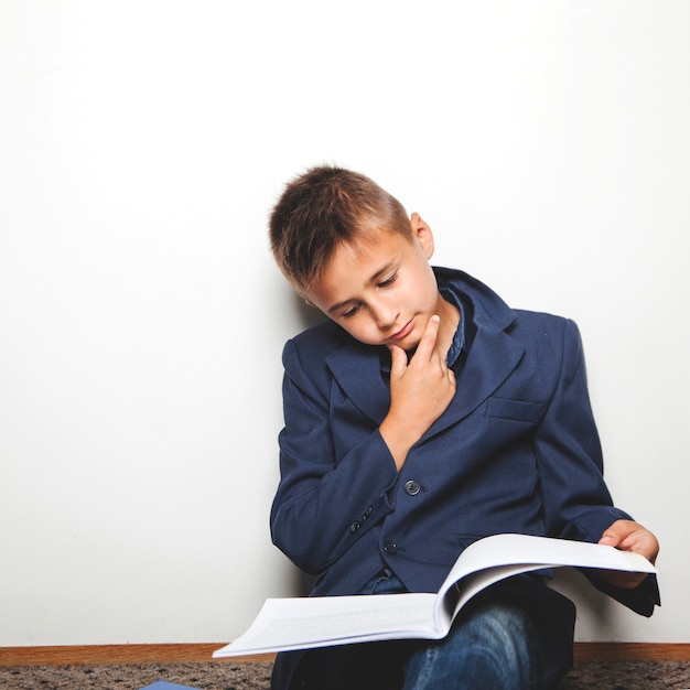 Free Photo | Thoughtful schoolboy reading book Free Photo | Thoughtful schoolboy reading book