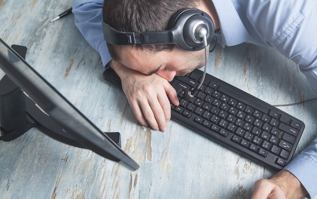Premium Photo | Tired call center operator sleeping in office desk. Premium Photo | Tired call center operator sleeping in office desk.