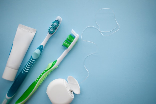 Premium Photo | Two toothbrushes and dental floss on blue Premium Photo | Two toothbrushes and dental floss on blue