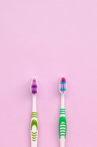Premium Photo | Two toothbrushes lie on a pastel pink background Premium Photo | Two toothbrushes lie on a pastel pink background