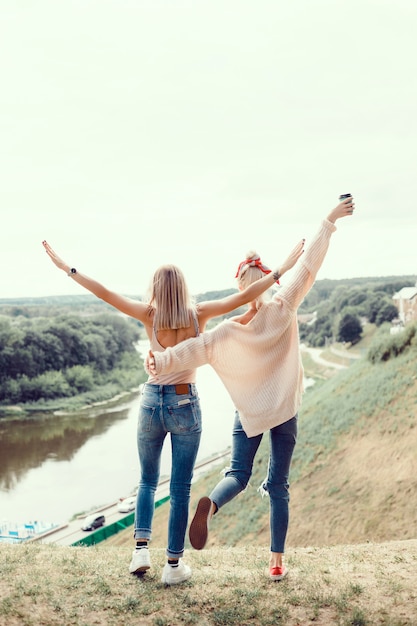 Free Photo | Two young girls sisters posing on the street, make selfie Free Photo | Two young girls sisters posing on the street, make selfie