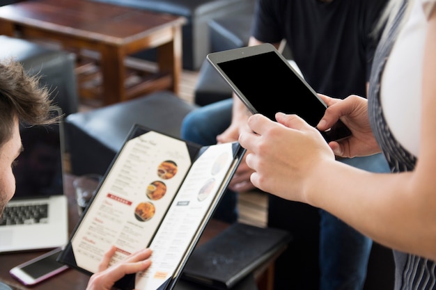 Waitress using digital tablet while taking order at restaurant | Free Photo Waitress using digital tablet while taking order at restaurant | Free Photo