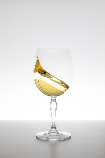 Premium Photo White Wine Swirling In Glass On White Background