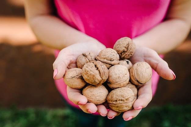Premium Photo | Woman holding whole walnut in her hands. Premium Photo | Woman holding whole walnut in her hands.