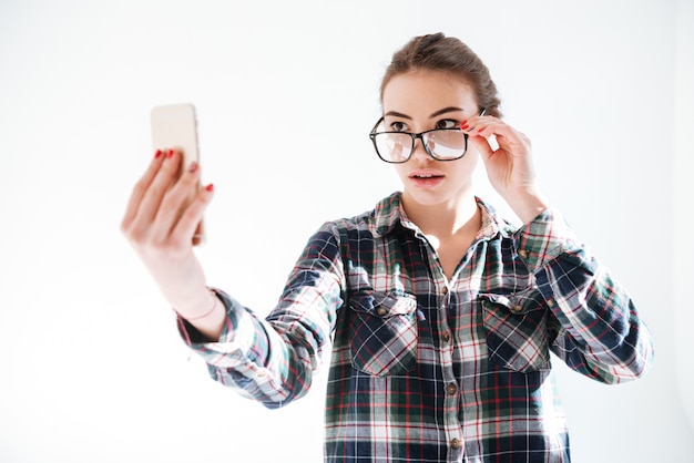 Premium Photo Woman Looking Over Glasses And Taking Selfie With Cell
