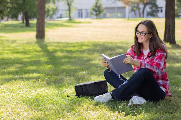Premium Photo Woman Sitting On The Grass And Reading Book