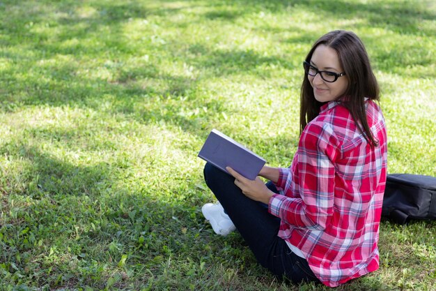 Premium Photo Woman Sitting On The Grass And Reading Book