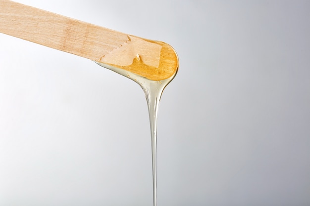 Premium Photo | Wooden stick with sugaring paste on light surface Premium Photo | Wooden stick with sugaring paste on light surface