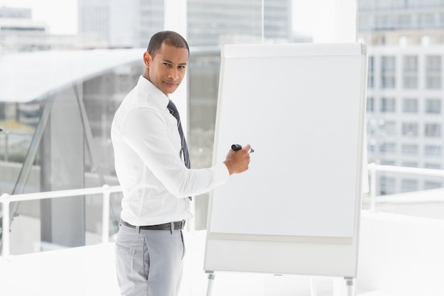 Premium Photo | Young businessman presenting at whiteboard with marker Premium Photo | Young businessman presenting at whiteboard with marker
