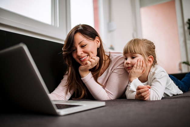 Premium Photo Young Mother And Daughter Watching Pictures On Laptop