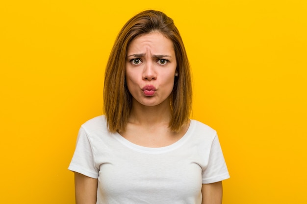 Premium Photo Young Natural Caucasian Woman Blows Cheeks Has Tired