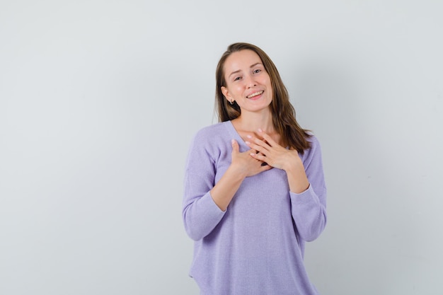 Free Photo Young Woman Holding Hand On Her Chest In Lilac Blouse And Looking Hopeful Front
