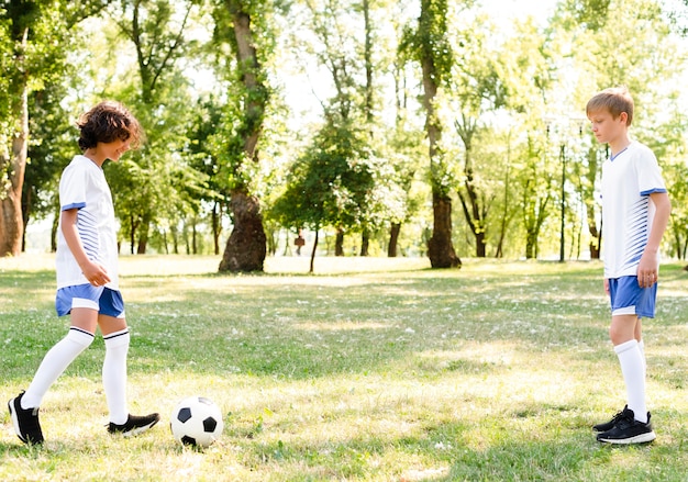 Enfants Jouant Ensemble Au Football à Lextérieur Photo Gratuite
