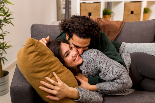 Homme Embrassant Sa Femme Souriante En Position Couchée Sur Le Canapé