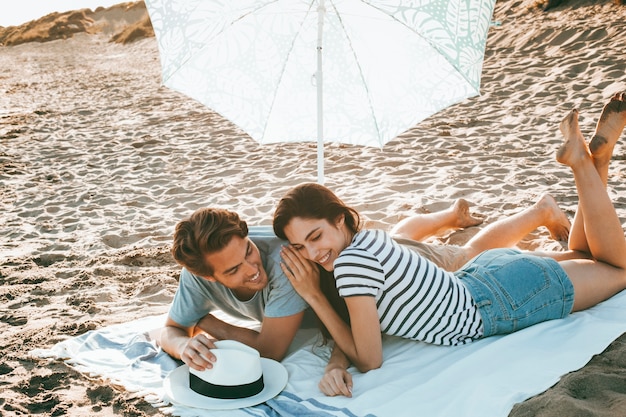 Jeune Couple Allongé Sur La Plage Photo Gratuite