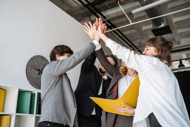 Joyeux Jeune Groupe De Personnes Debout Dans Le Bureau Et Donnant Cinq ... Joyeux Jeune Groupe De Personnes Debout Dans Le Bureau Et Donnant Cinq ...