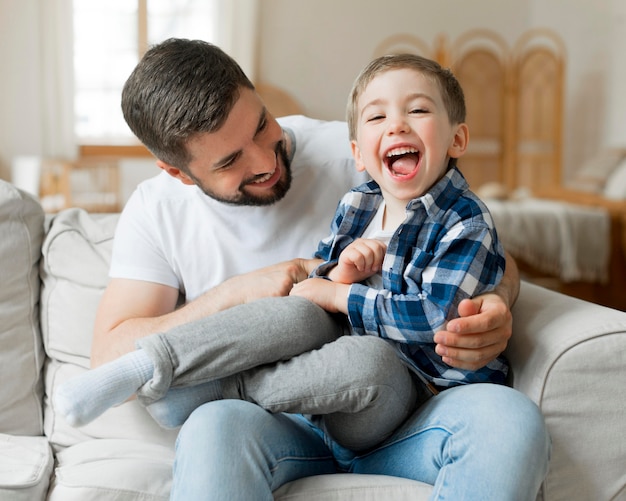 Père Jouant Avec Son Fils Sur Le Canapé Photo Gratuite