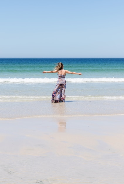 Vrouw het ontspannen bij het strand met open wapens genietend van haar ... Vrouw het ontspannen bij het strand met open wapens genietend van haar ...